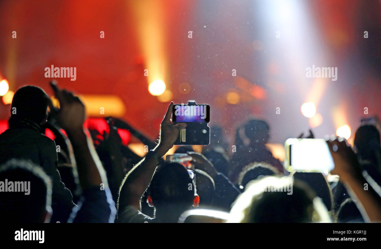 fans take pictures with modern smartphones during the live concert of a ...