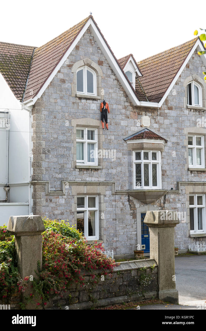 wetsuit hanging out to dry from third floor window of ornate house in ...