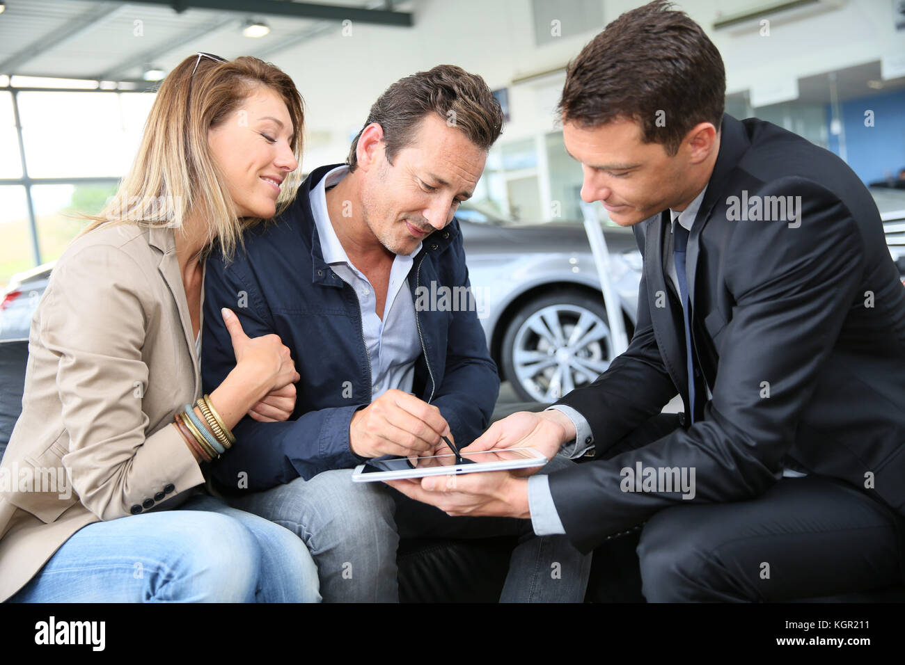 Couple signing car purchase order on digital tablet Stock Photo - Alamy