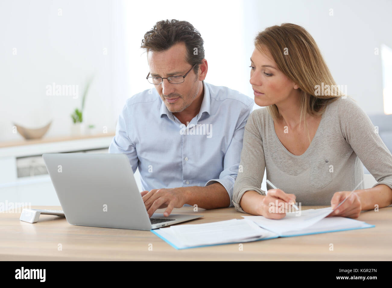 Couple at home working on laptop computer Stock Photo - Alamy