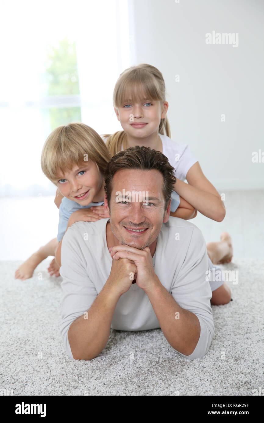 Daddy with kids laying on carpet Stock Photo - Alamy