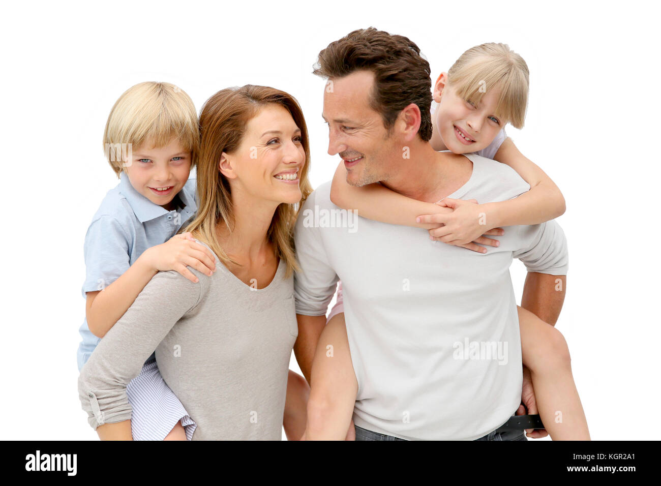 Parents giving piggyback ride to kids Stock Photo - Alamy