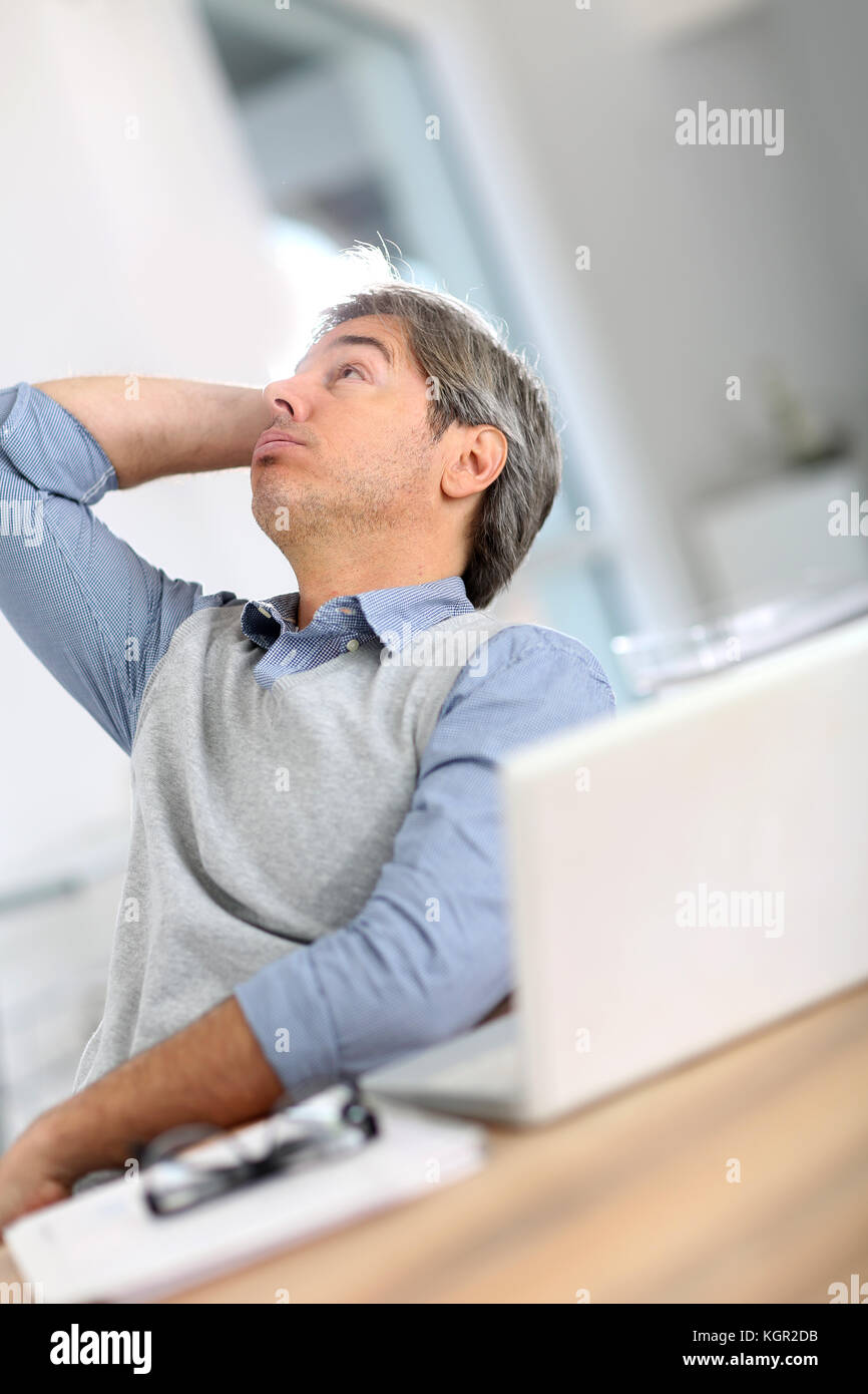 Senior businessman being tired at work Stock Photo - Alamy