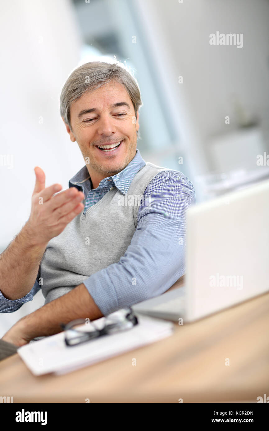 Happy businessman reading good news on laptop Stock Photo - Alamy