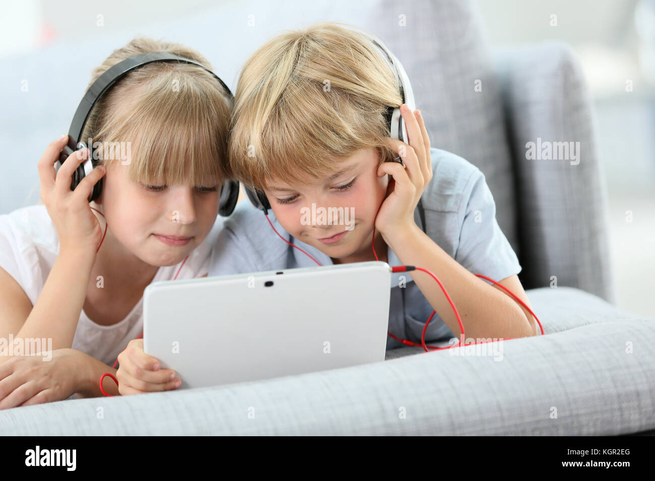 Kids listening to music on internet with tablet Stock Photo - Alamy