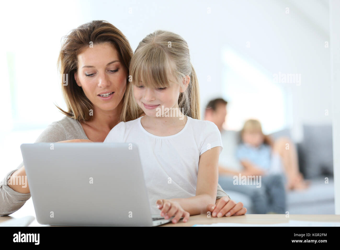Mother and daughter using laptop computer at home Stock Photo - Alamy