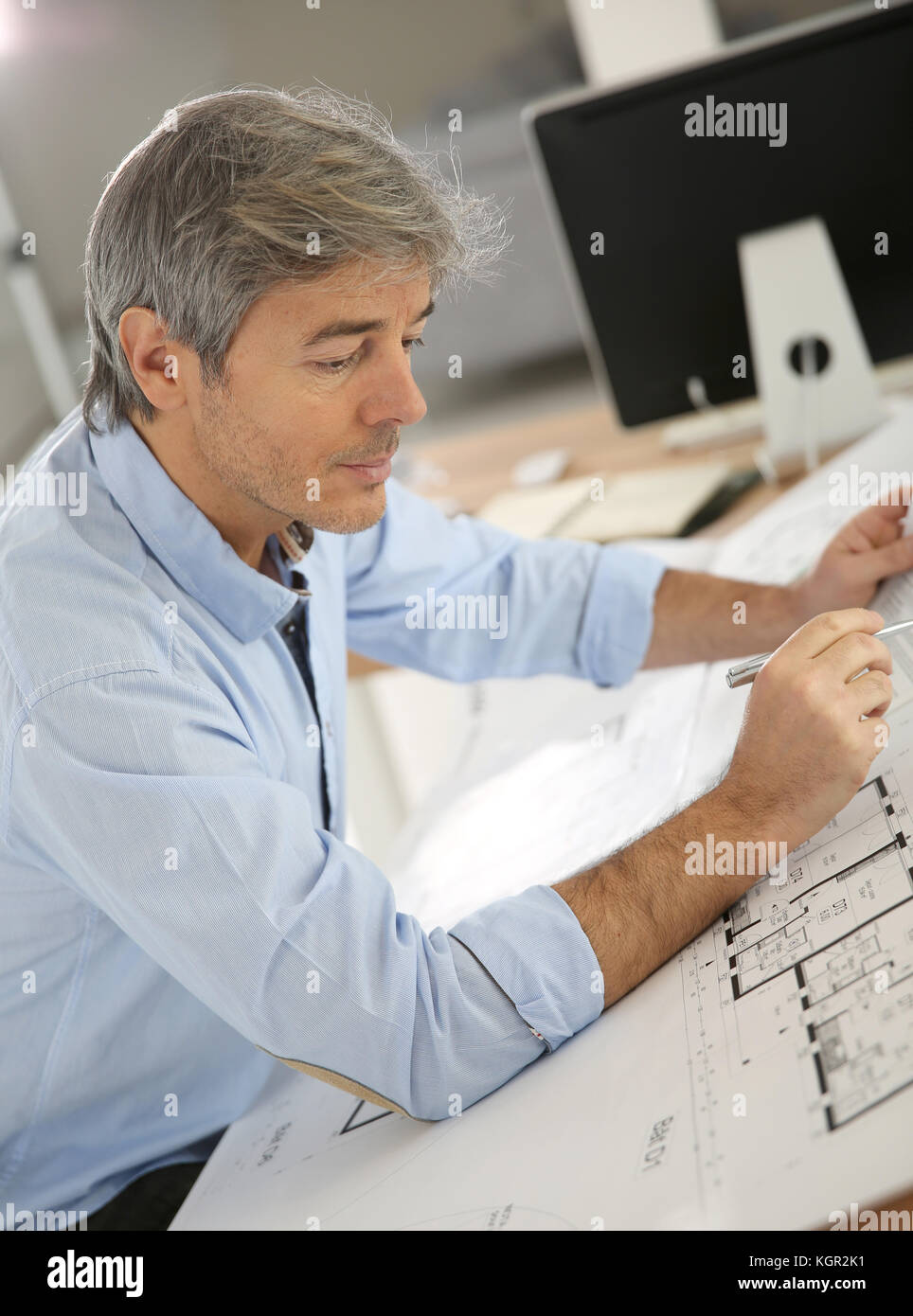 Architect working on blueprint in office Stock Photo - Alamy