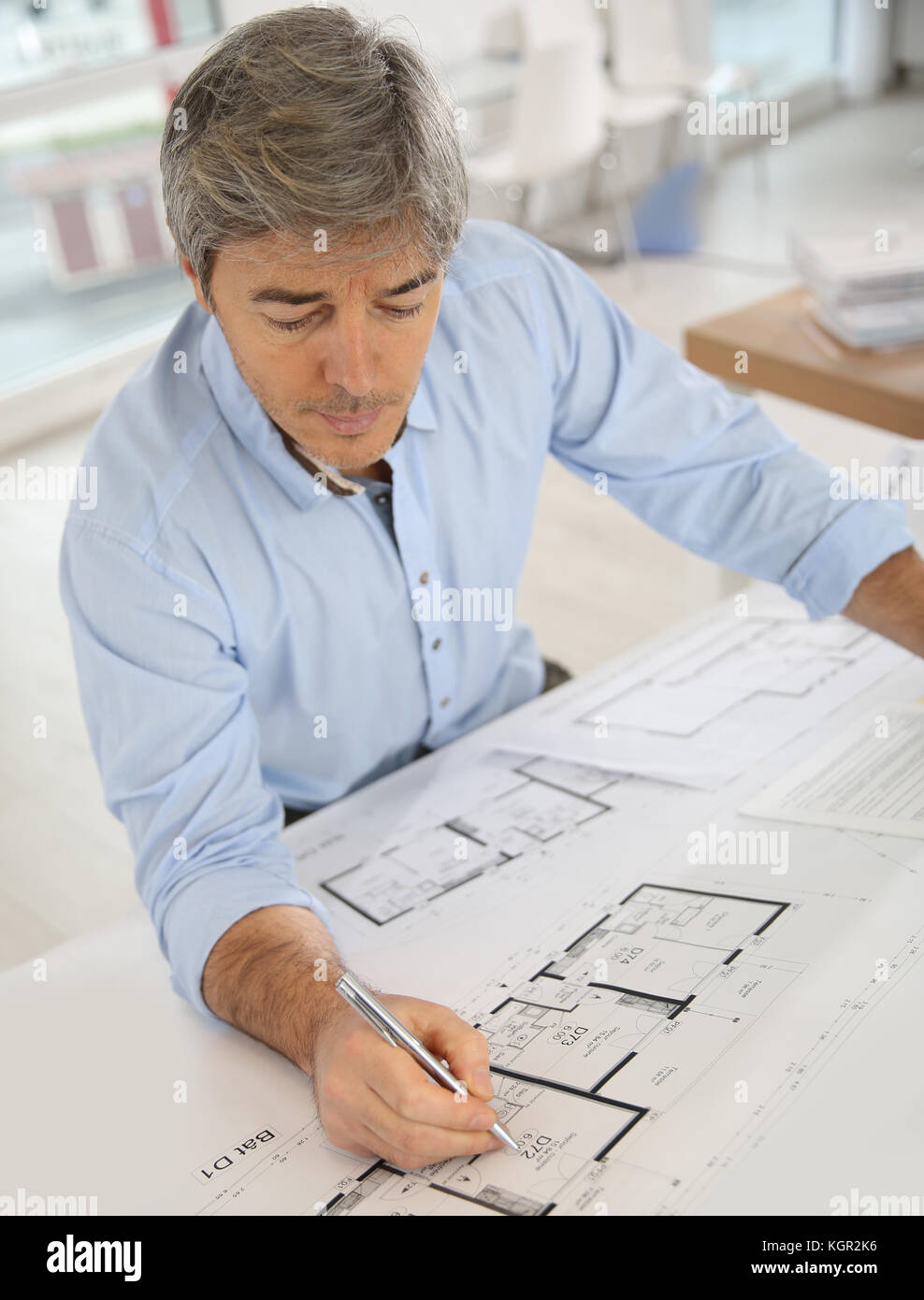 Architect working on blueprint in office Stock Photo - Alamy
