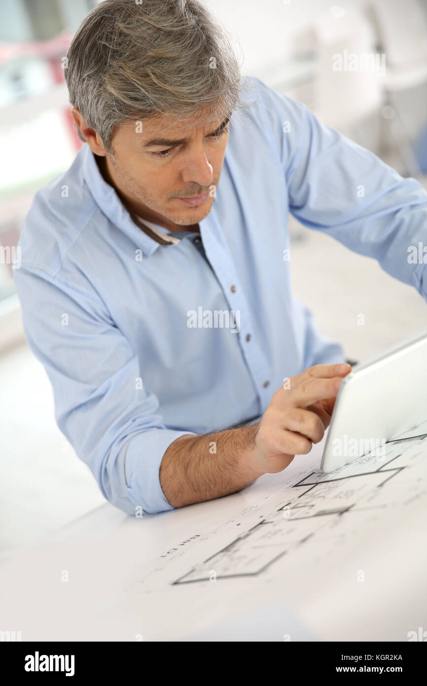 Architect working on blueprint in office Stock Photo - Alamy