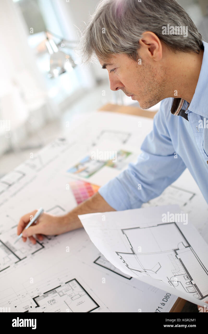 Architect working on blueprint in office Stock Photo - Alamy
