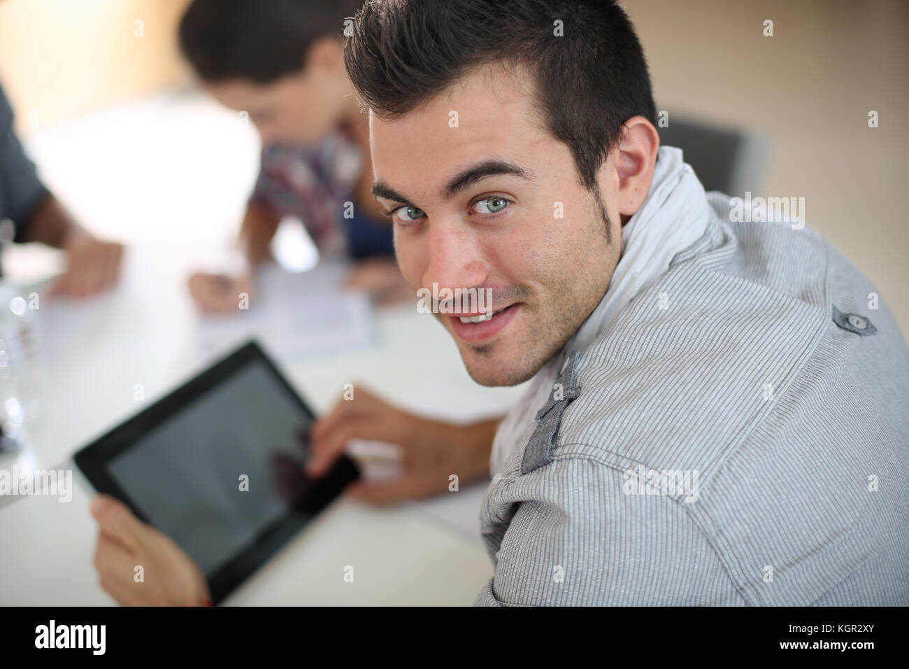 Cheerful student using tablet in class Stock Photo - Alamy