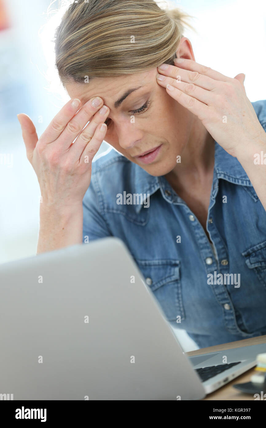 Woman in front of laptop suffering headache Stock Photo - Alamy
