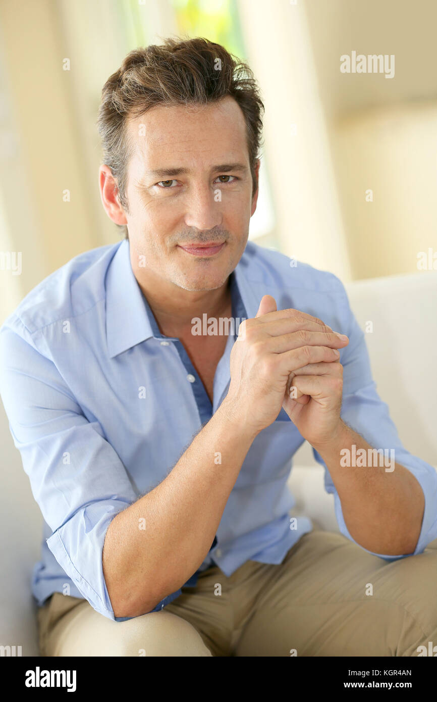 Portrait of single middle-aged man sitting in sofa Stock Photo - Alamy