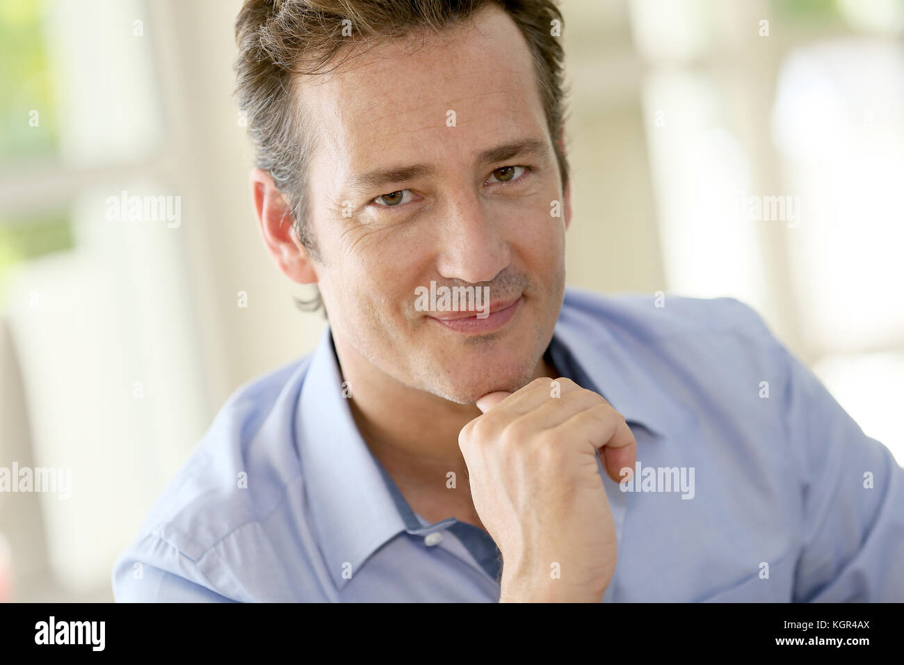 Portrait of single middle-aged man sitting in sofa Stock Photo - Alamy