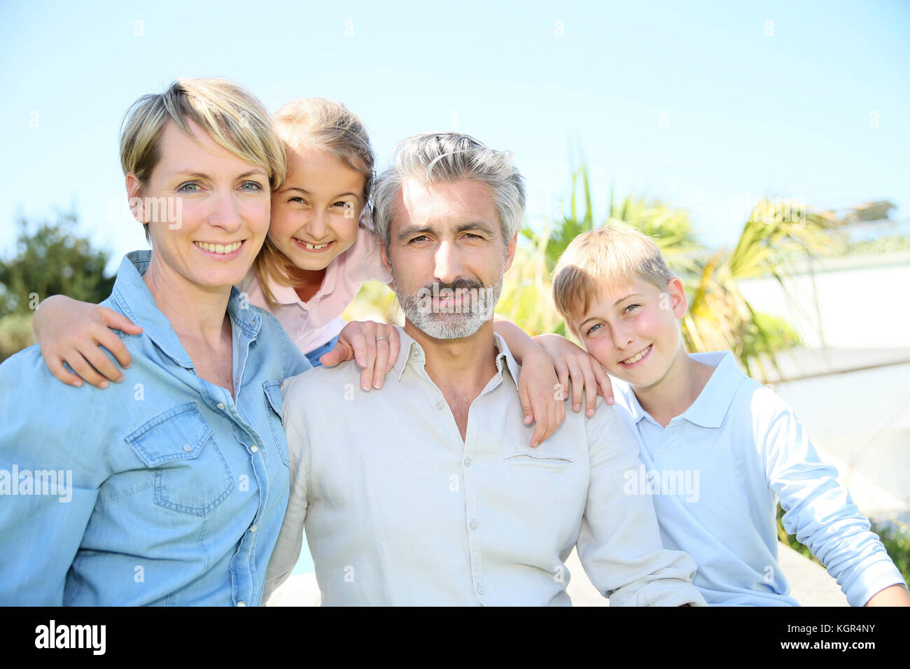 Happy family standing in home private garden Stock Photo - Alamy