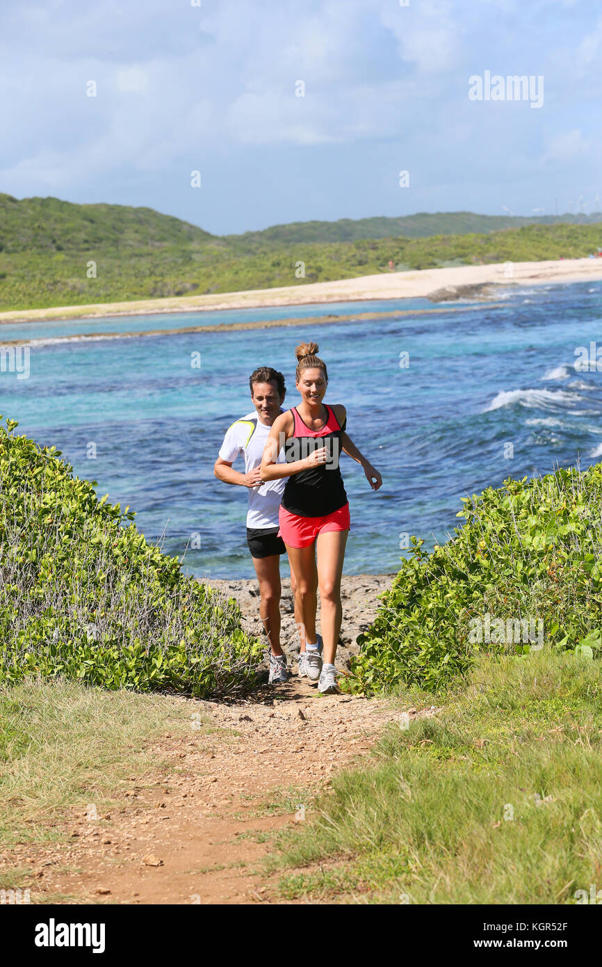 Couple running by the sea on track Stock Photo - Alamy