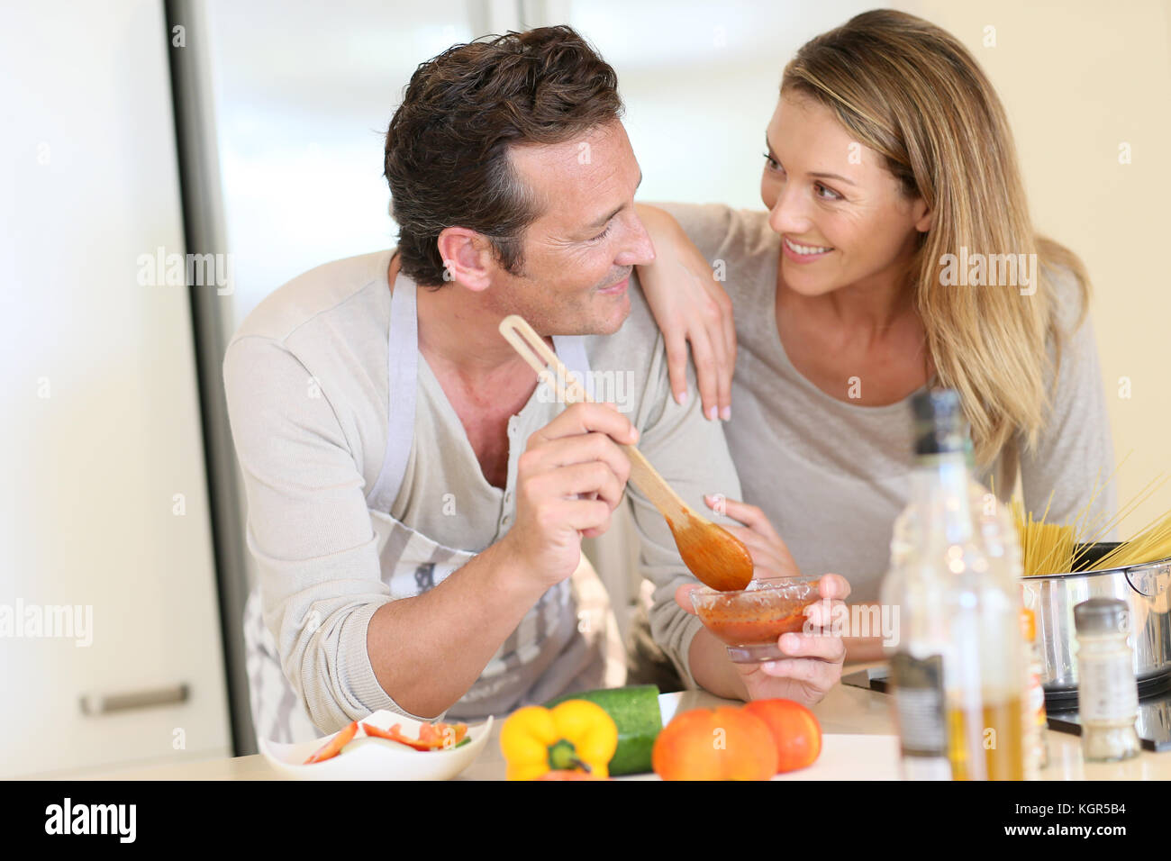 Woman cooking man watching hi-res stock photography and images - Alamy