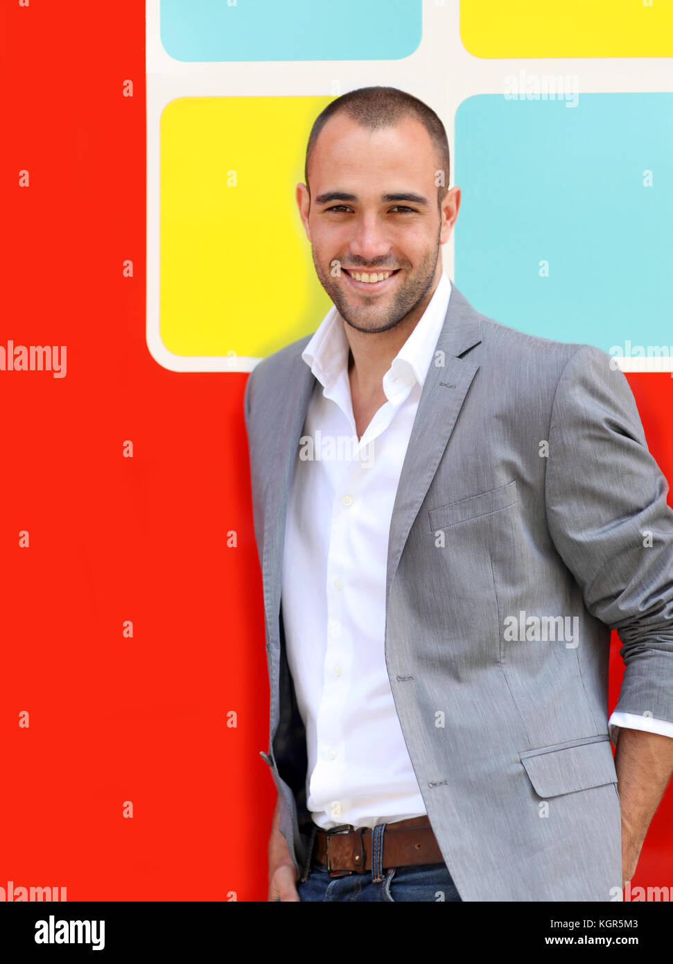 Handsome man standing on colorful wall Stock Photo - Alamy