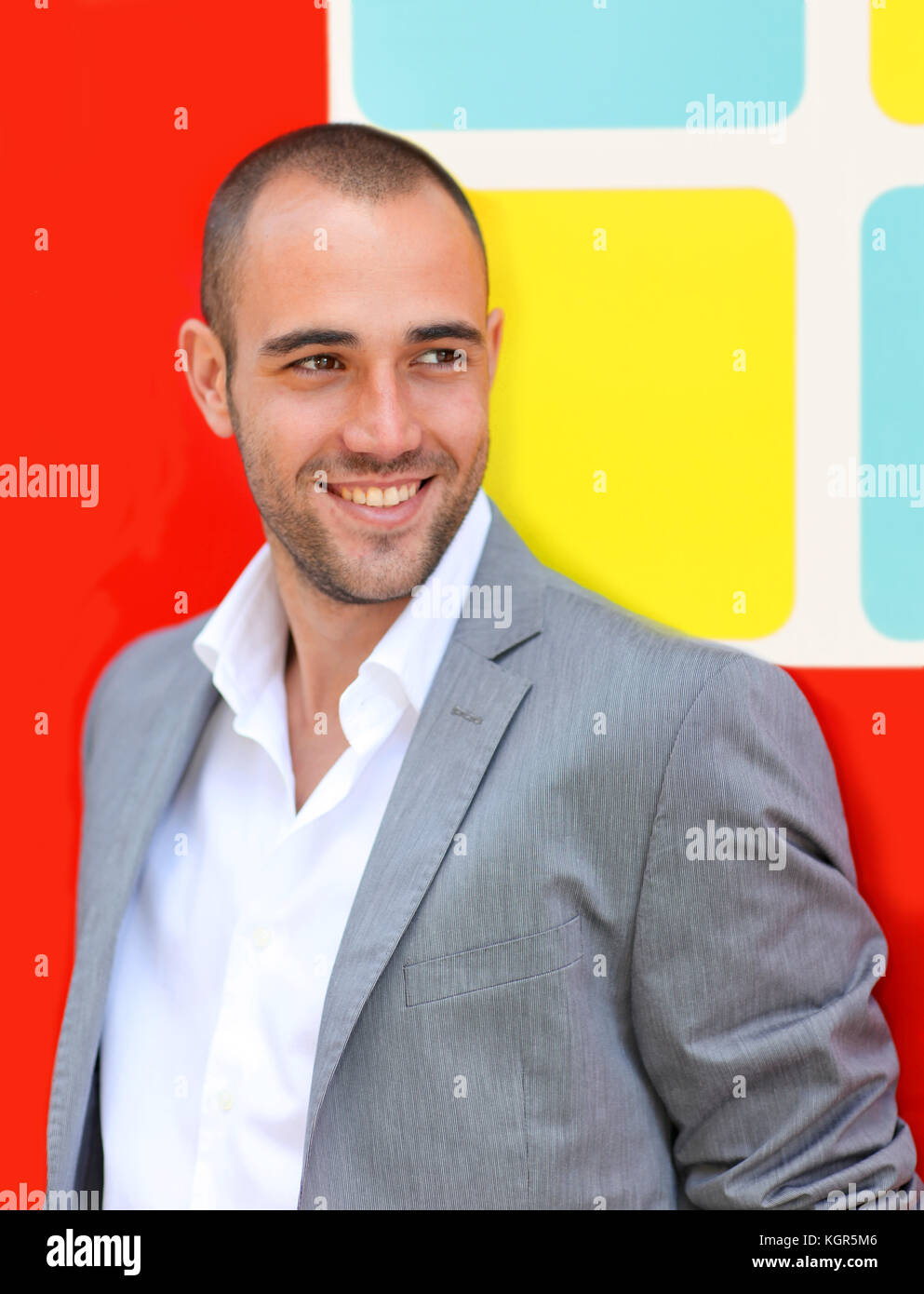 Handsome man standing on colorful wall Stock Photo - Alamy