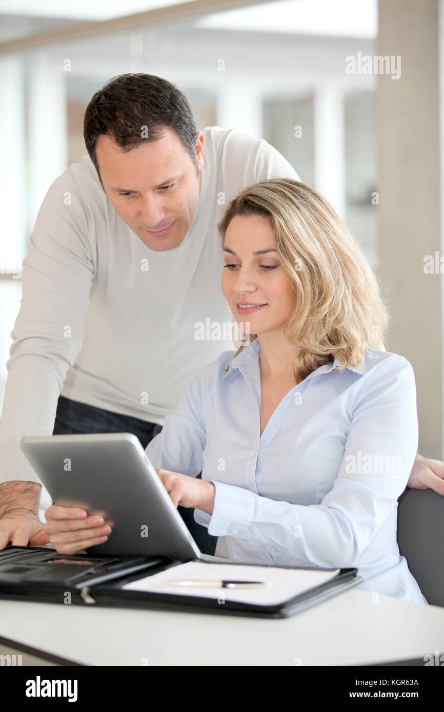 Office workers using electronic tab in the office Stock Photo - Alamy