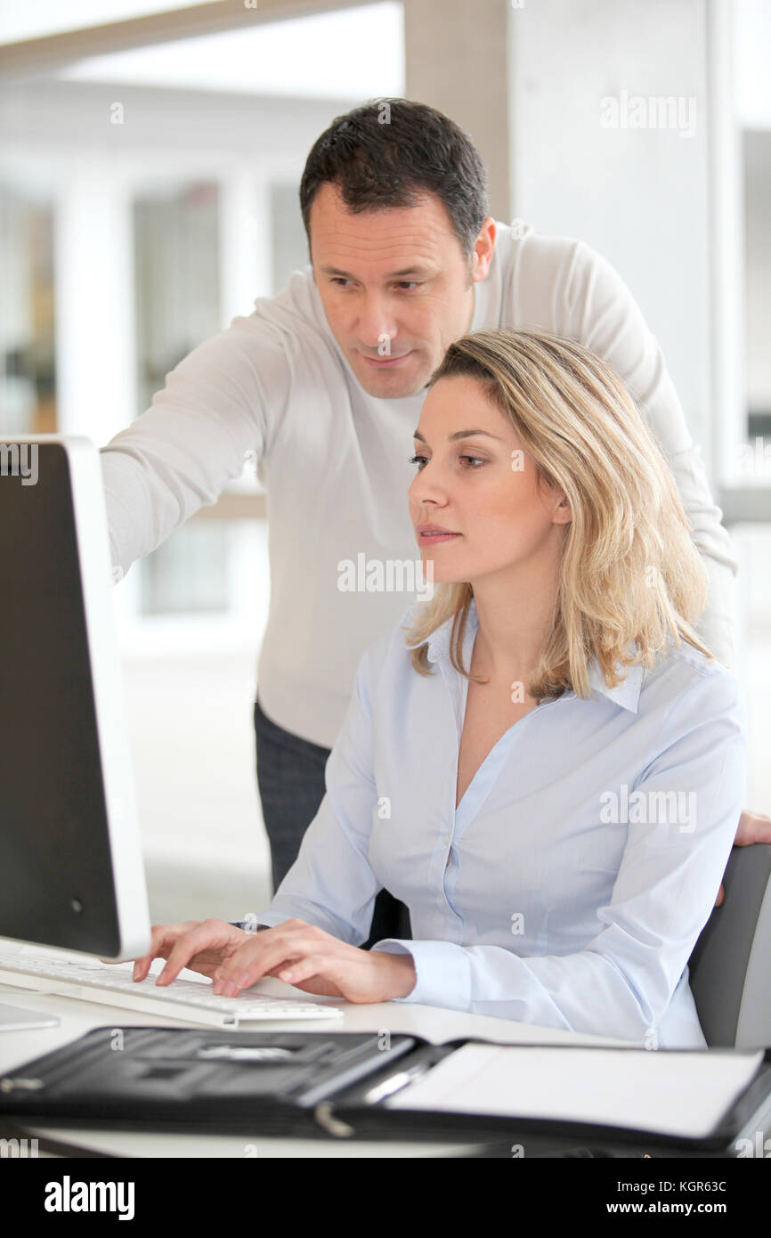 Office workers in front of desktop computer Stock Photo - Alamy