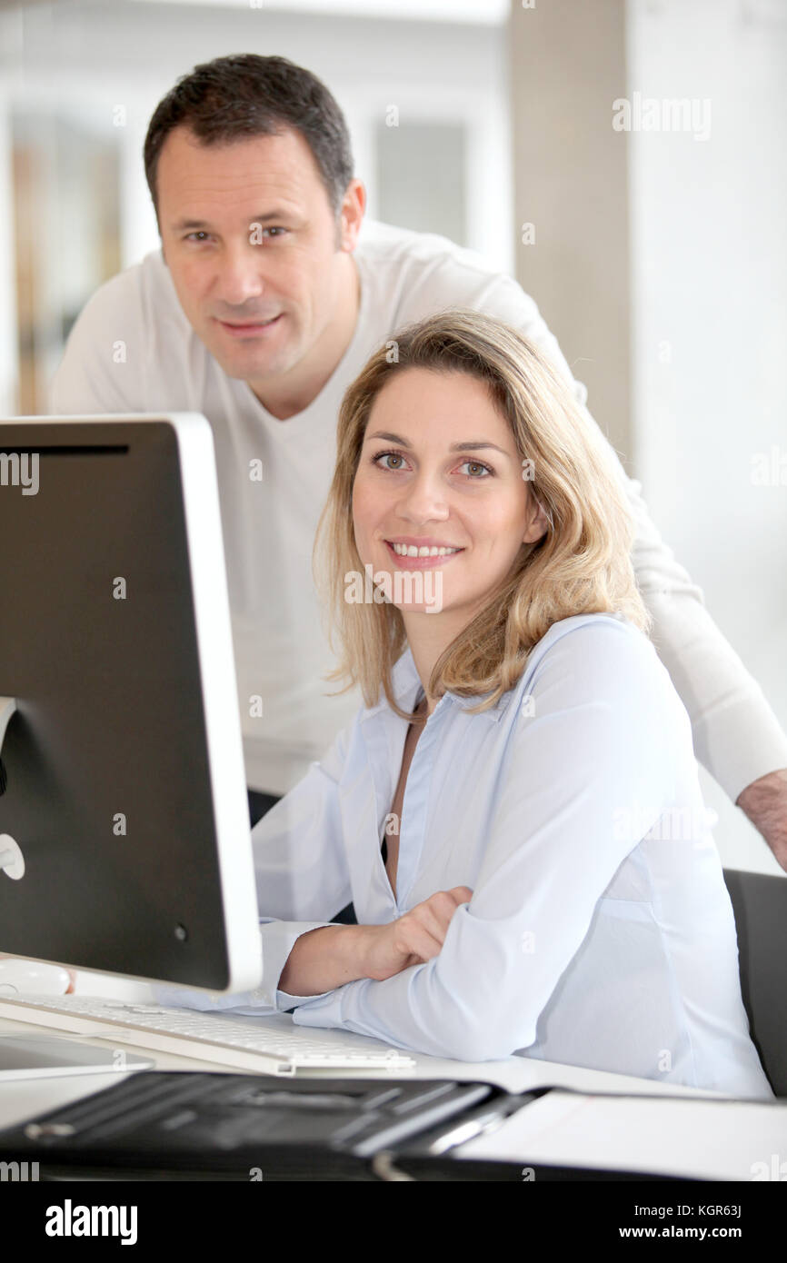 Office workers in front of desktop computer Stock Photo - Alamy