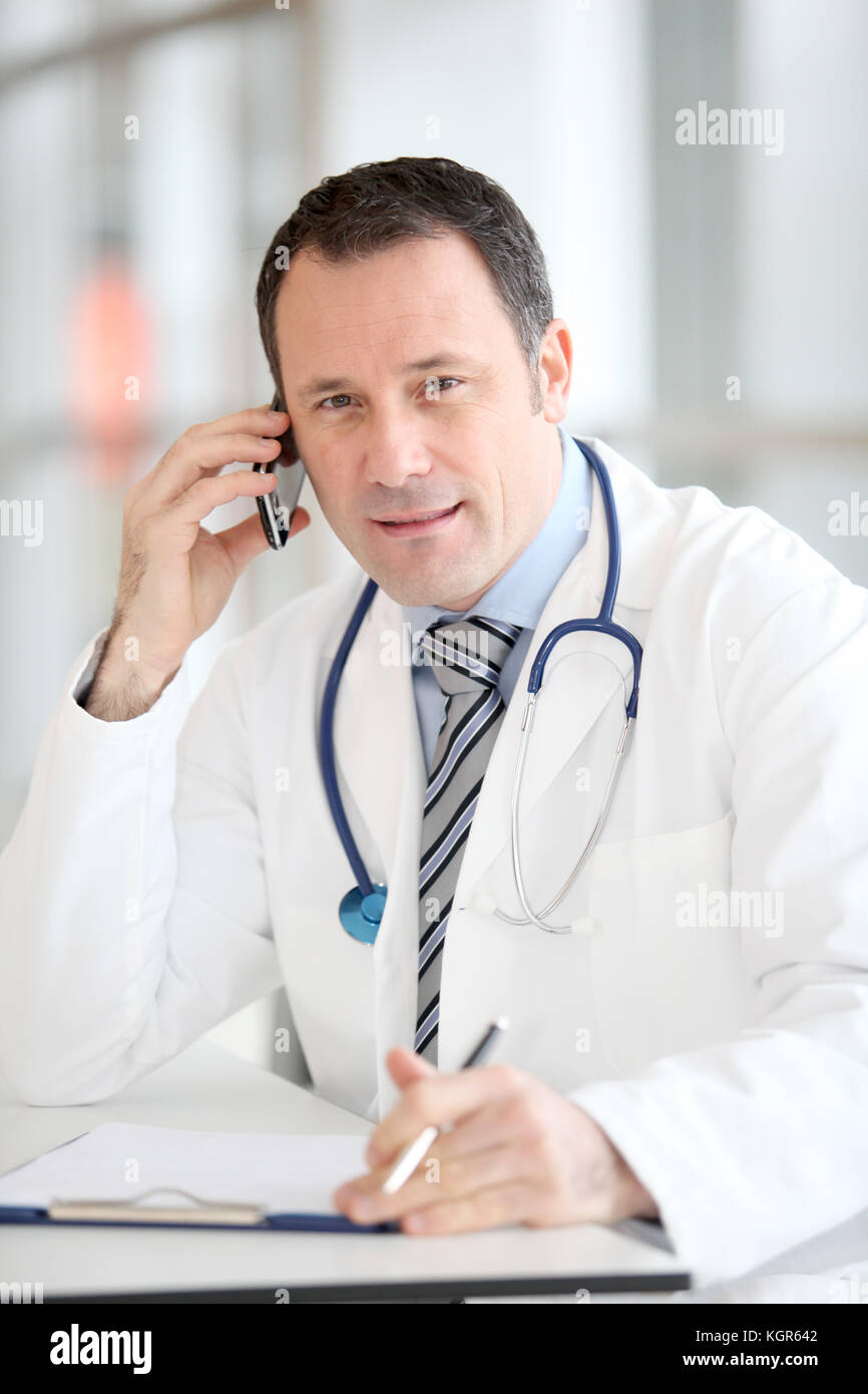Mature doctor talking on mobile hi-res stock photography and images - Alamy