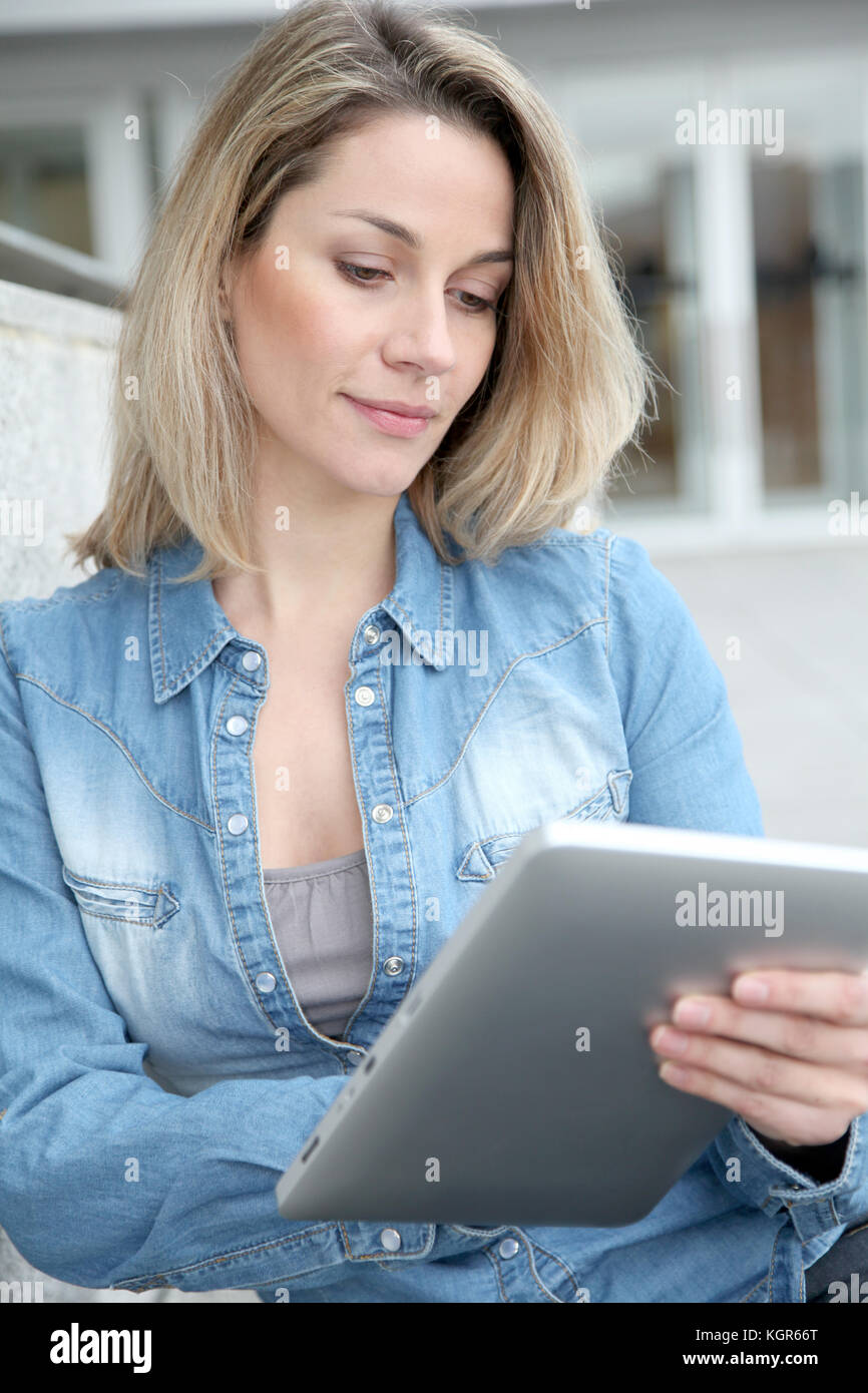 Beautiful woman using electronic tab in the street Stock Photo - Alamy