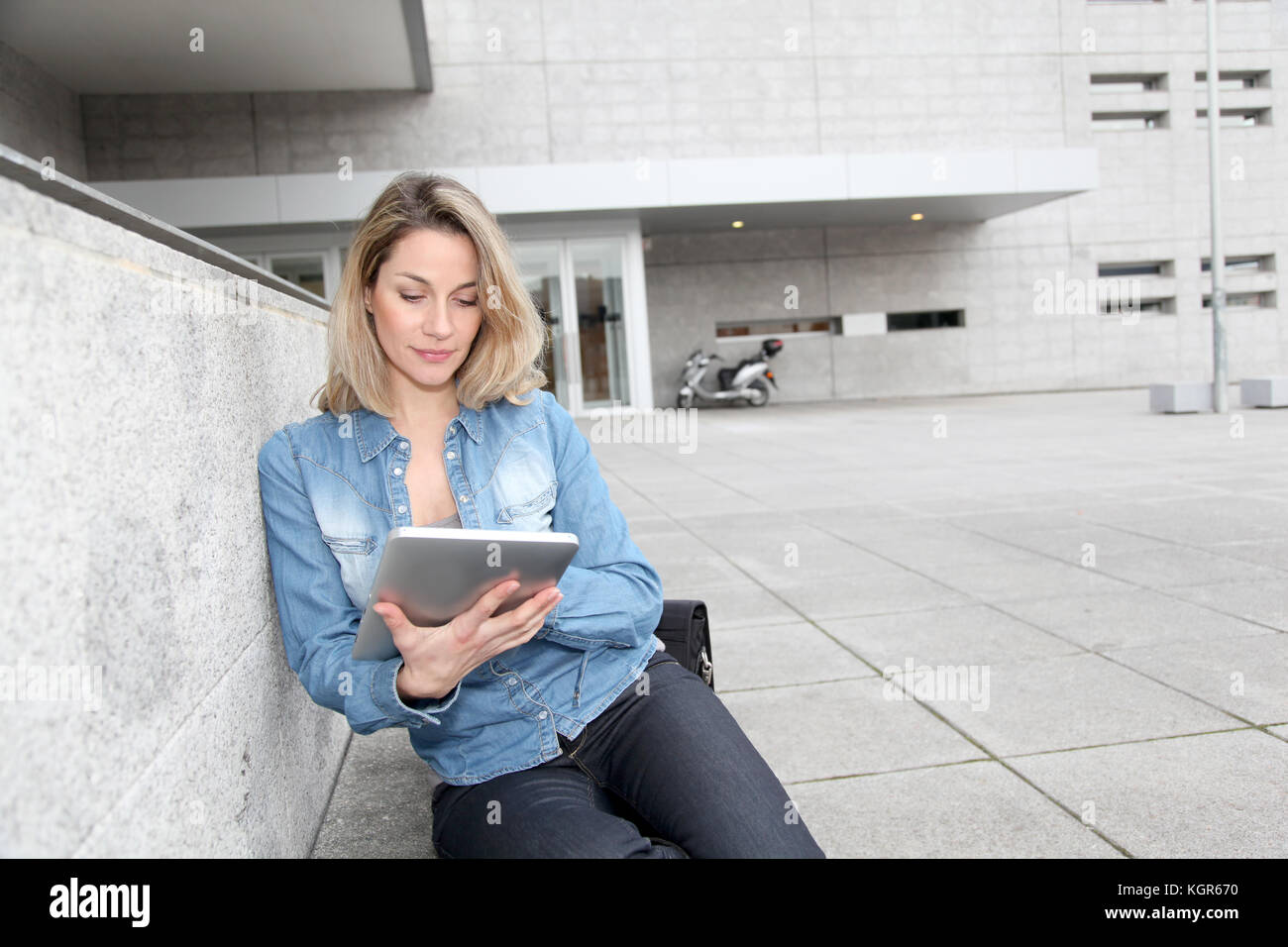 Beautiful woman using electronic tab in the street Stock Photo - Alamy