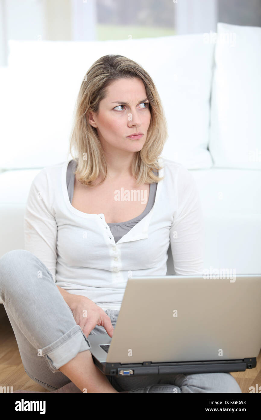 Woman with mad look using laptop computer Stock Photo - Alamy