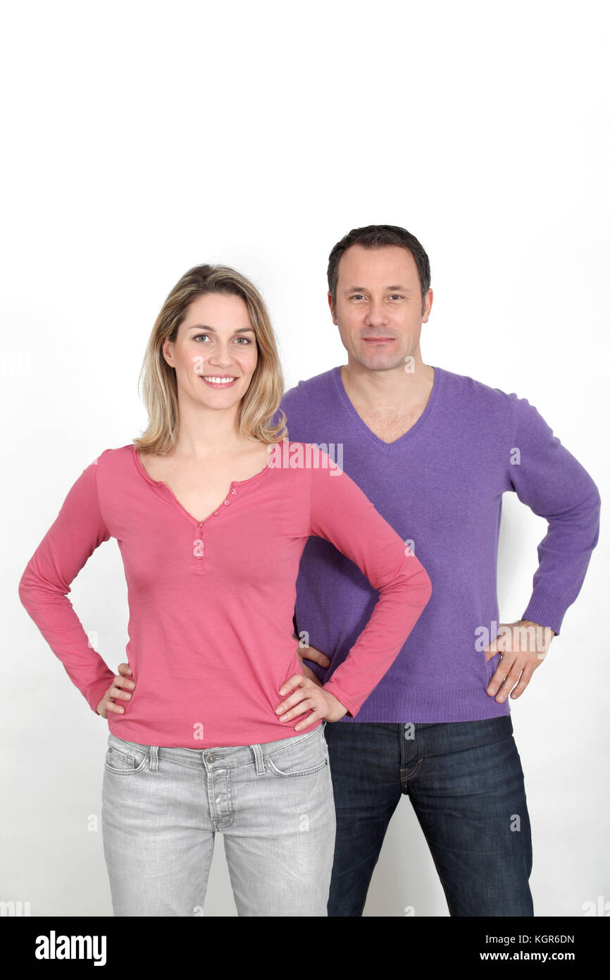 Couple standing on white background with hands on hips Stock Photo - Alamy