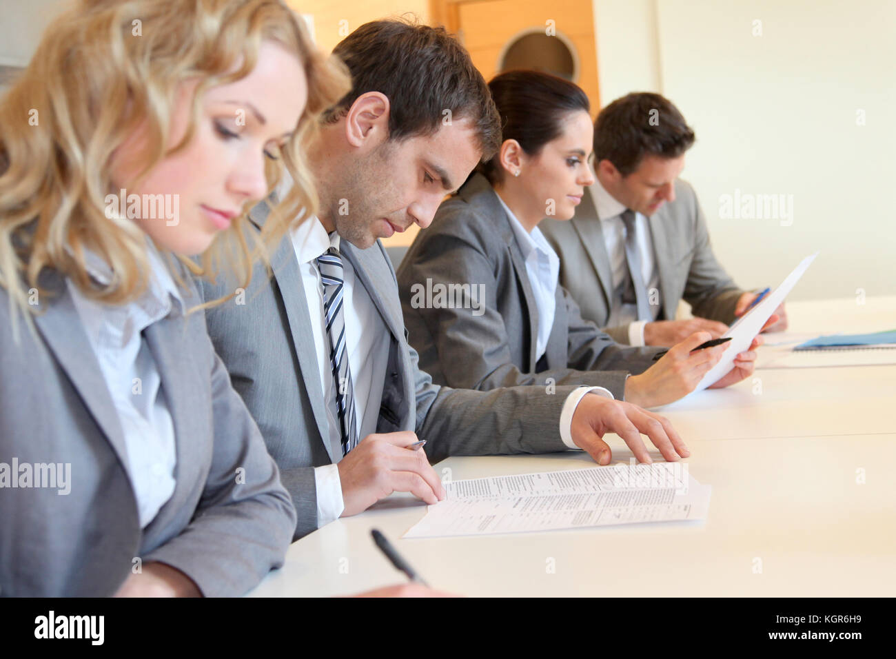 Young business people signing application form Stock Photo - Alamy