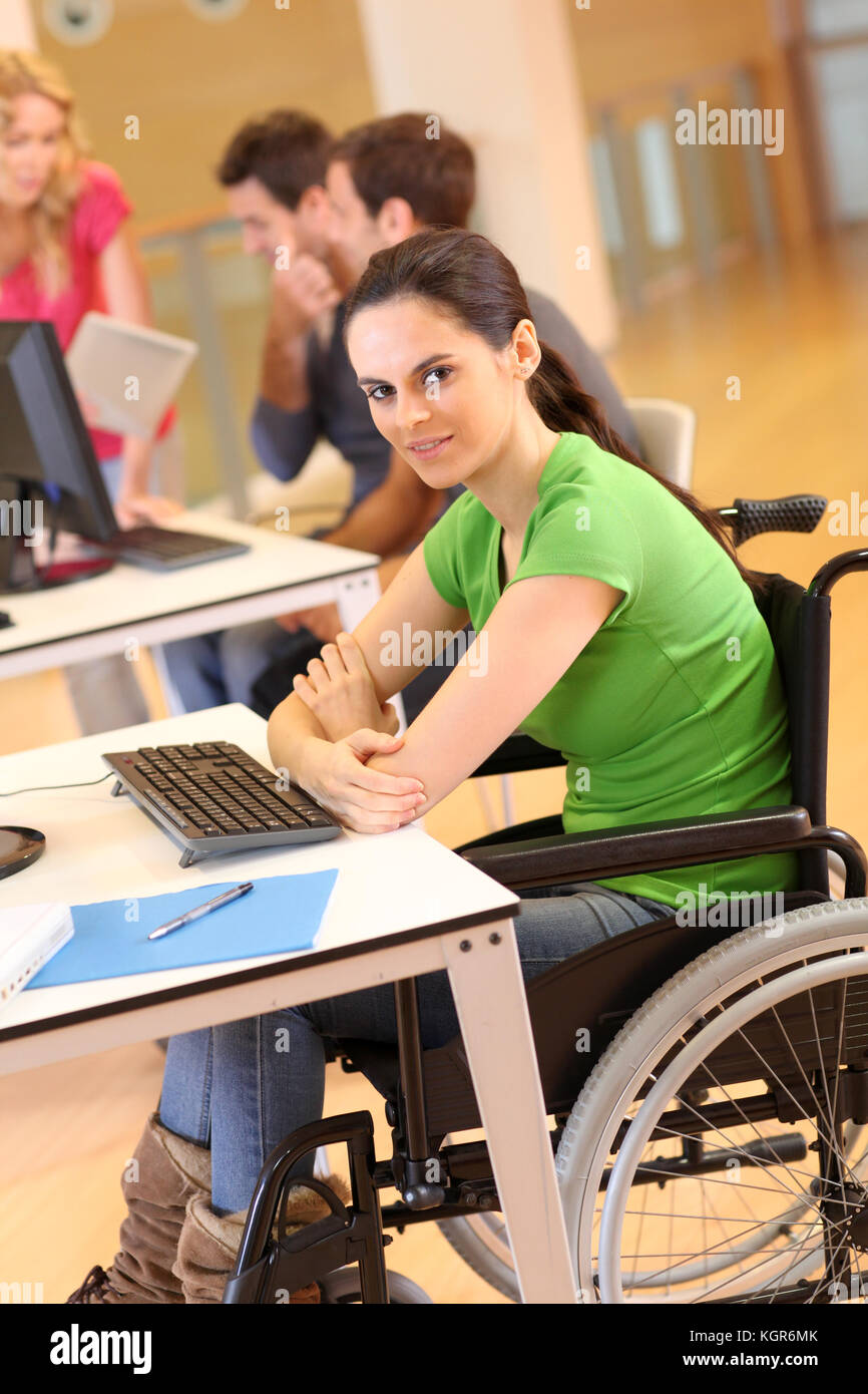 Young woman in wheelchair working in office Stock Photo - Alamy