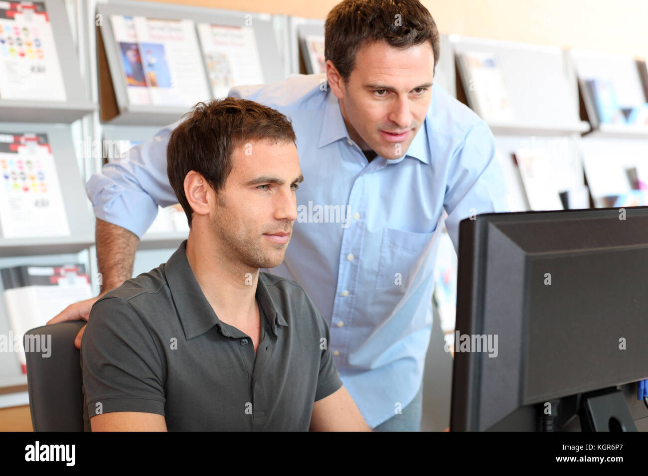Workmates in office in front of desktop Stock Photo - Alamy