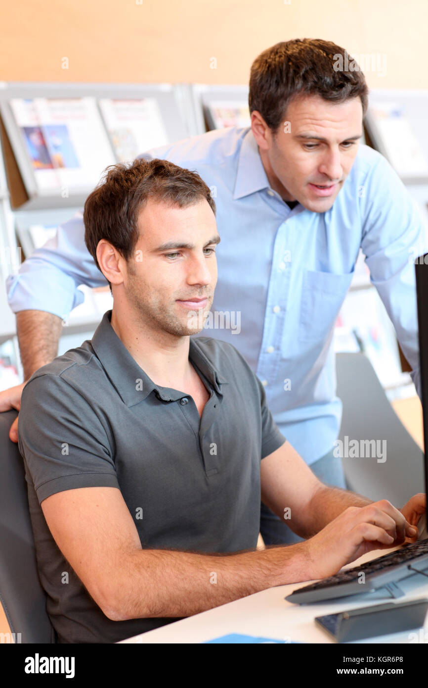 Workmates in office in front of desktop Stock Photo - Alamy