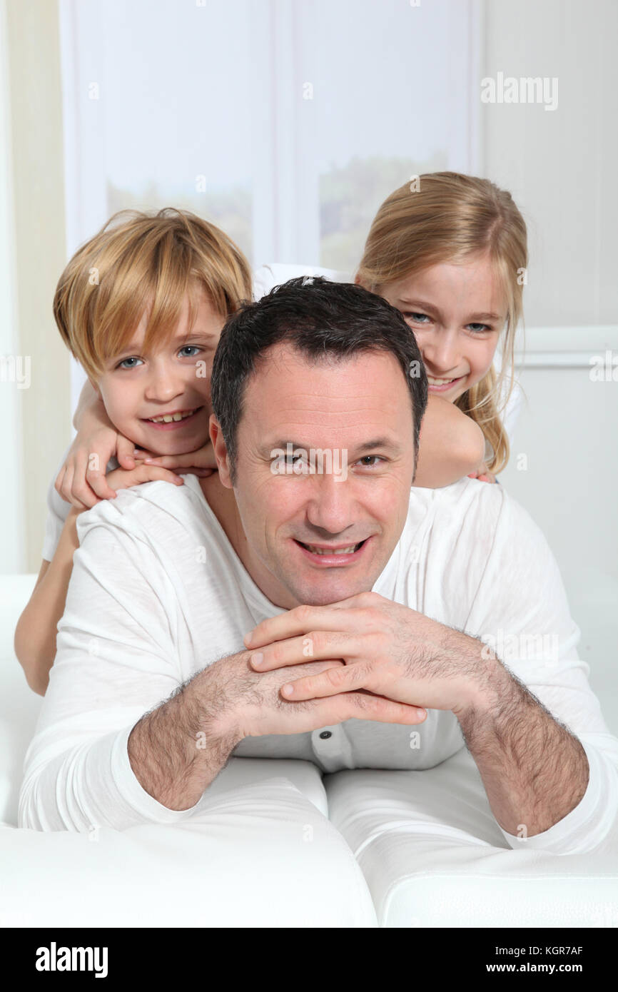 Portrait of father with children up on his back Stock Photo - Alamy