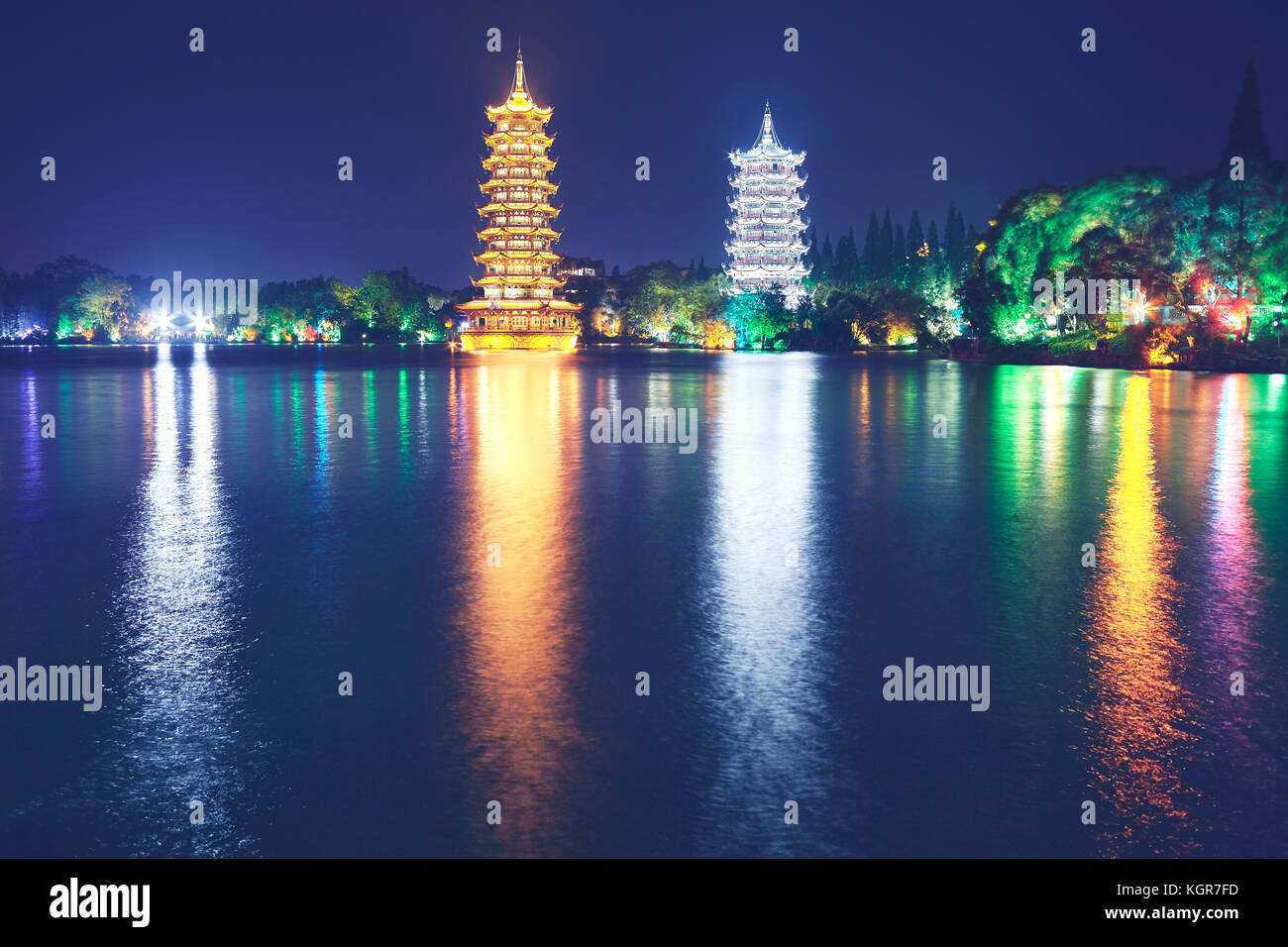 Guilin Sun and Moon Tower Pagodas in Fir Lake at night, color toned ...