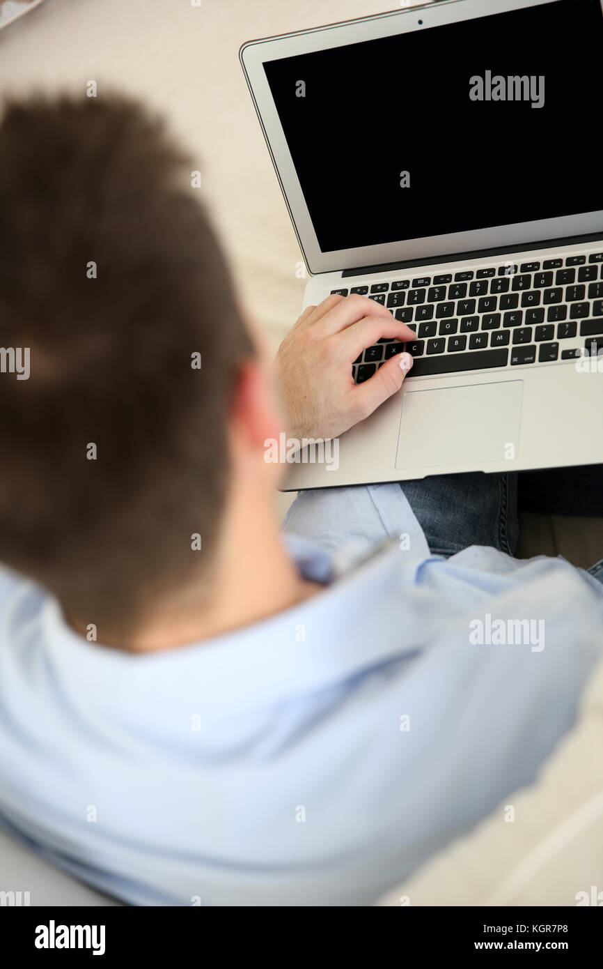 Upper back view of man in front of laptop screen Stock Photo - Alamy