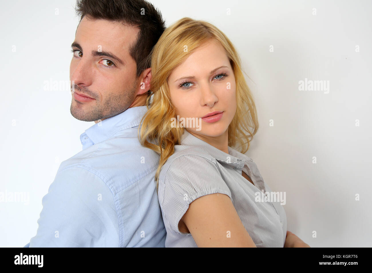 Couple standing back to back on white background Stock Photo - Alamy