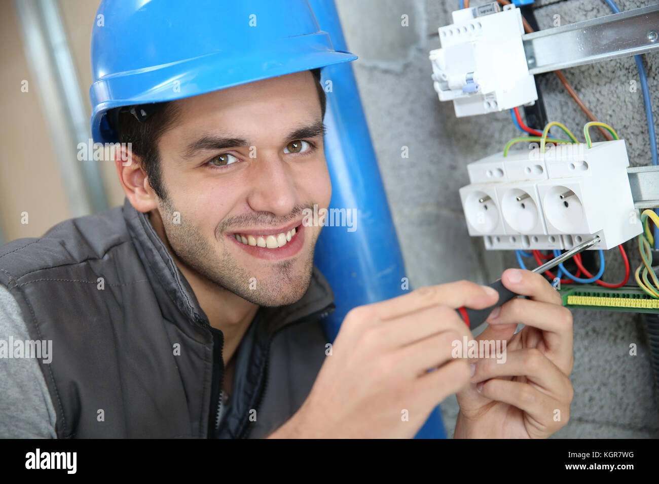 Young electrician working on building site Stock Photo - Alamy