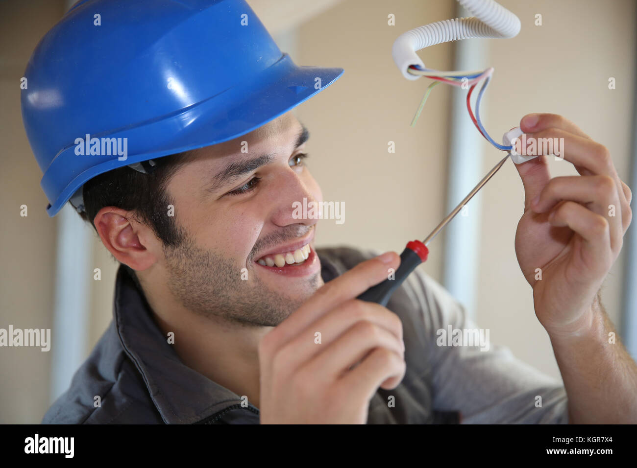 Young electrician working on building site Stock Photo - Alamy