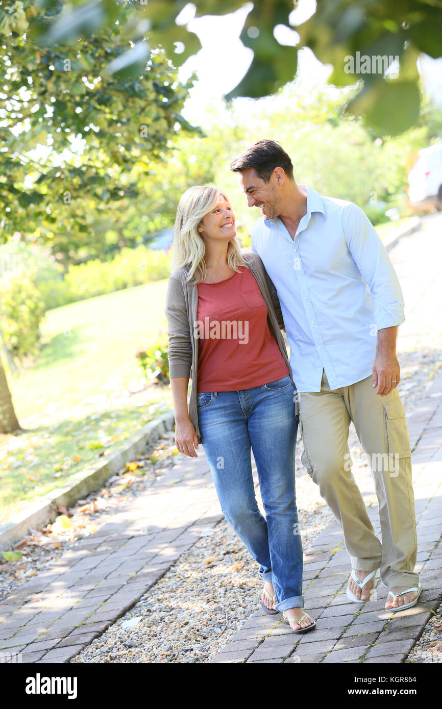 Couple walking hand in hand in park Stock Photo - Alamy
