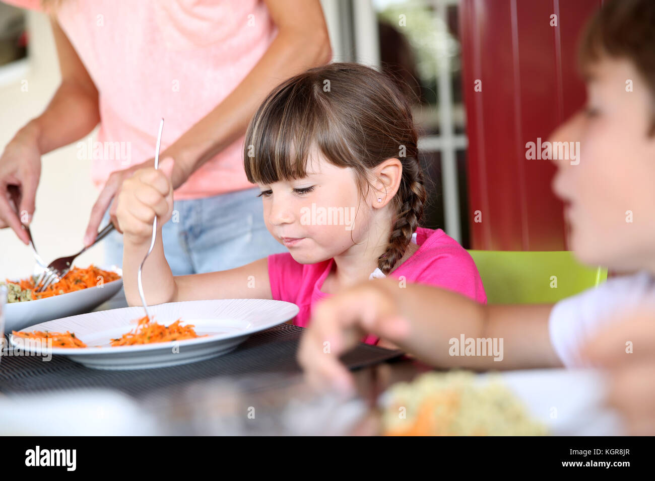 Portrait of little girl sitting at table for lunch Stock Photo - Alamy