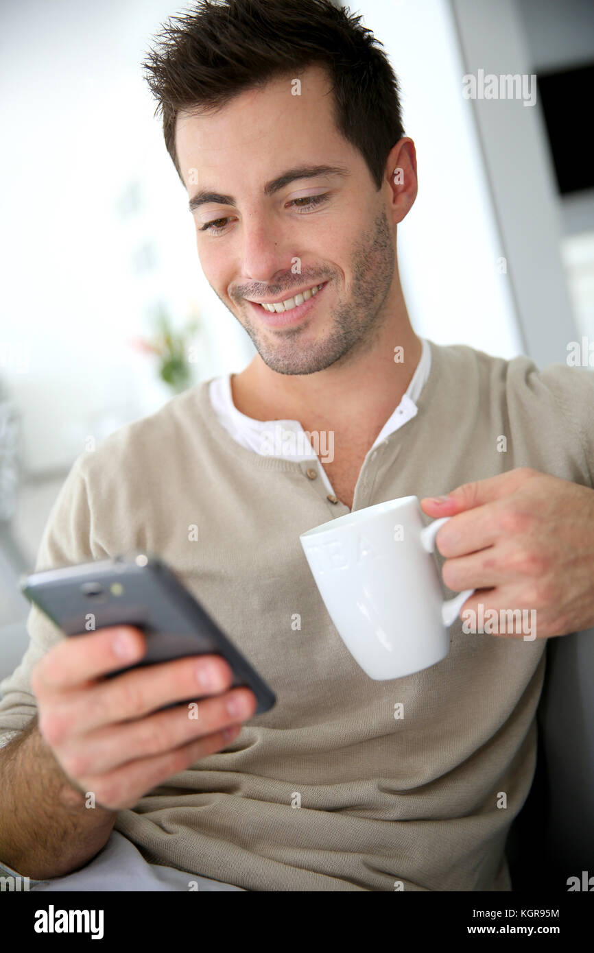 Man at home connected on smartphone Stock Photo - Alamy