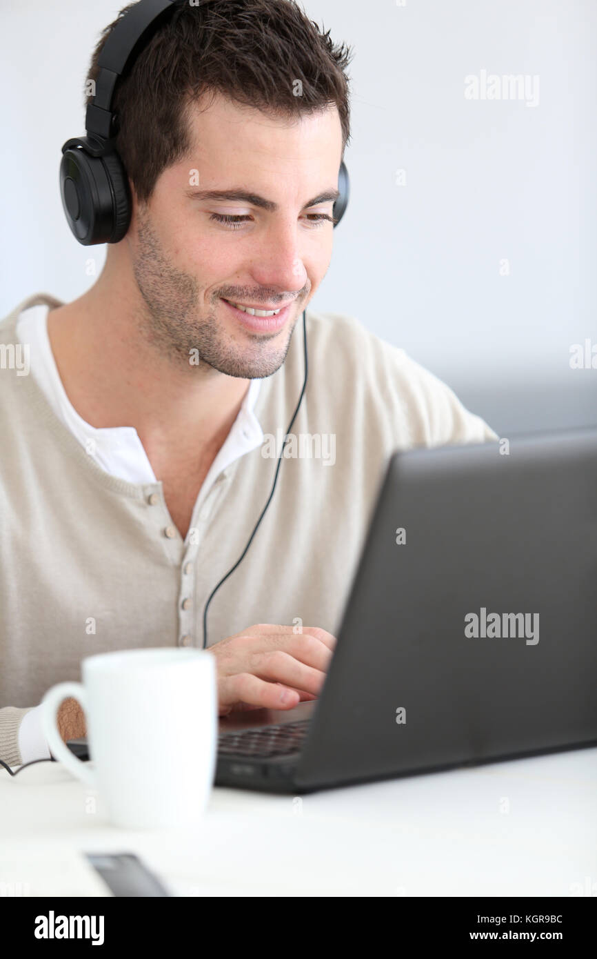 Man in front of laptop computer with headset Stock Photo - Alamy
