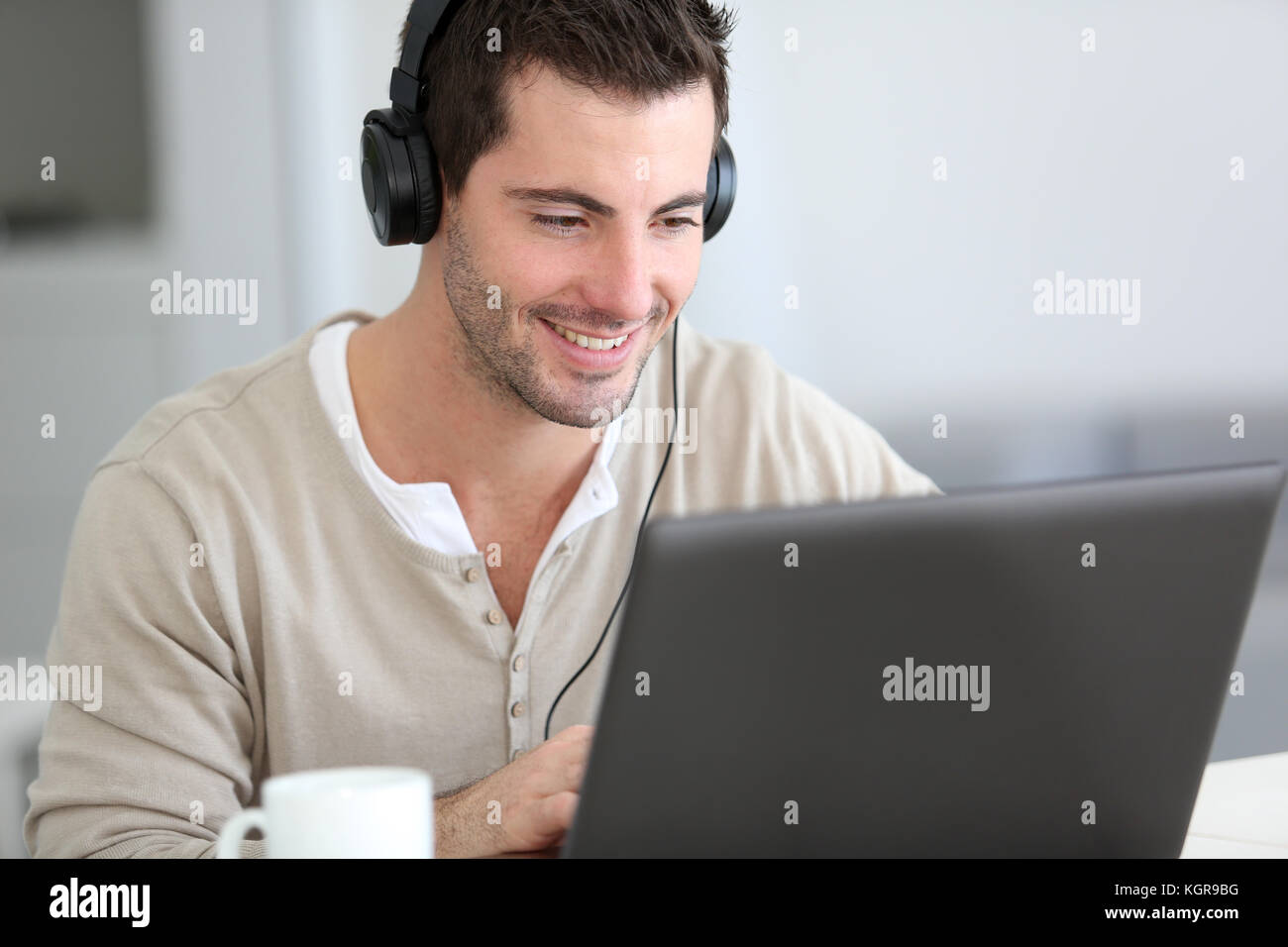 Man in front of laptop computer with headset Stock Photo - Alamy