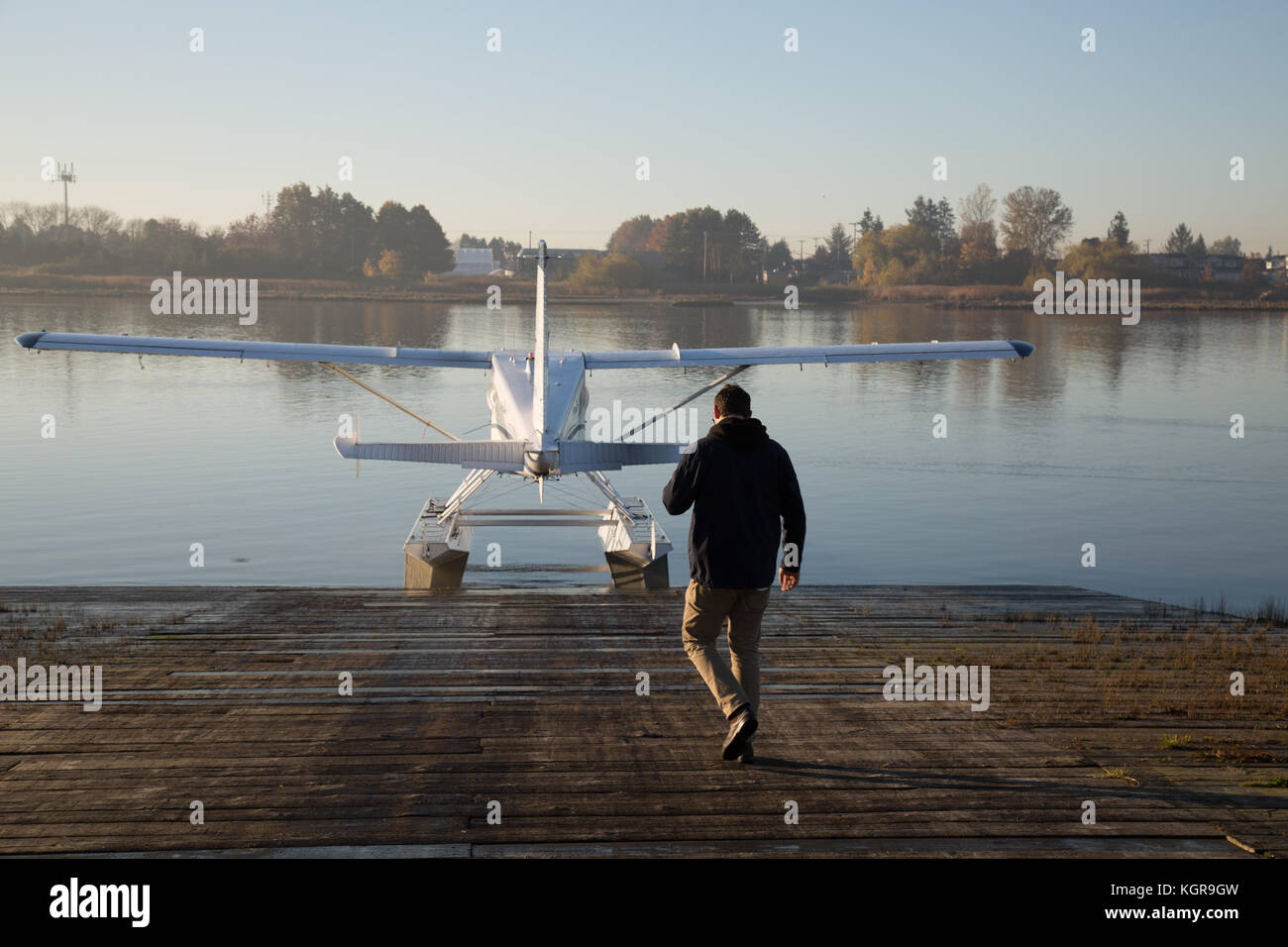 Male pilot walking toward seaplane water Stock Photo - Alamy