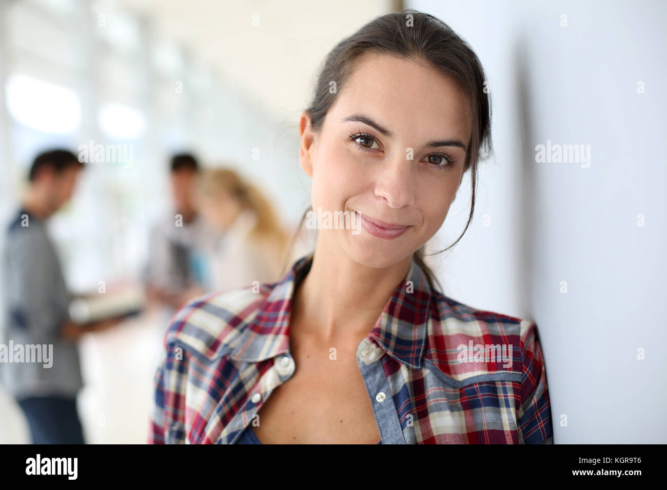 Smiling student girl standing in hall Stock Photo - Alamy