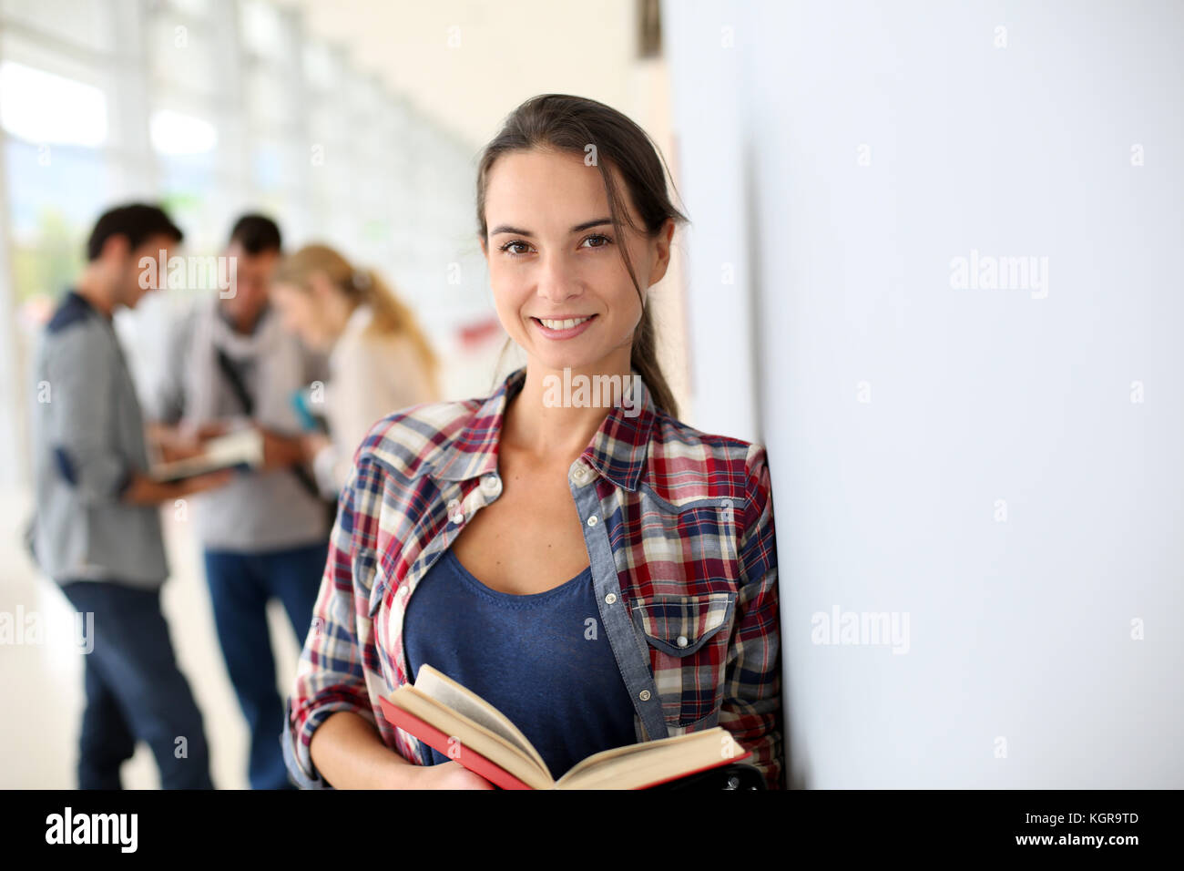 Smiling student girl standing in hall Stock Photo - Alamy
