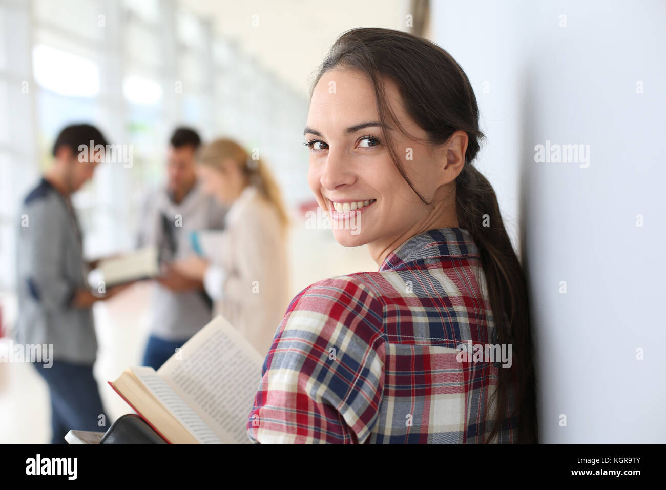 Smiling student girl standing in hall Stock Photo - Alamy